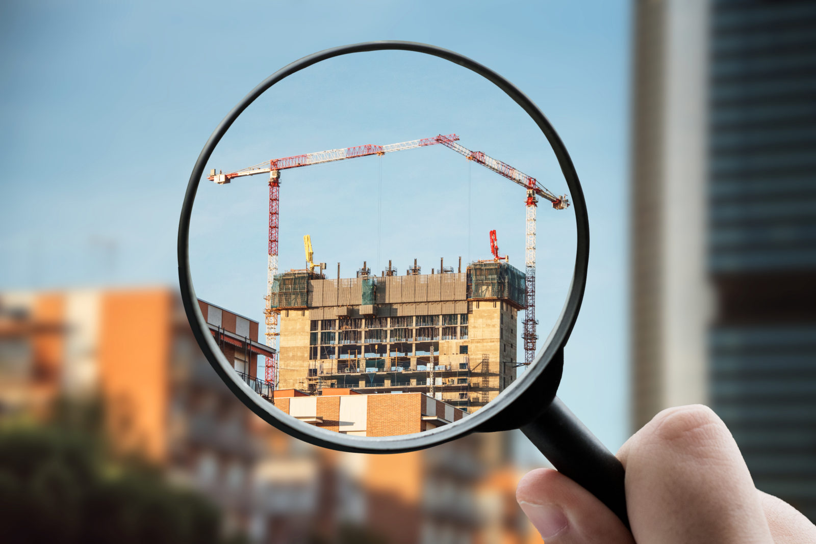 Magnifying glass focusing a building under construction - Kryton